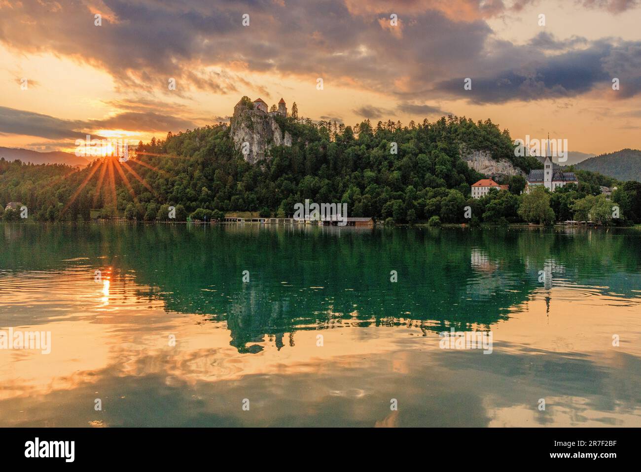 sunburst effect as the sun sets behind bled castle makes a beautiful ...
