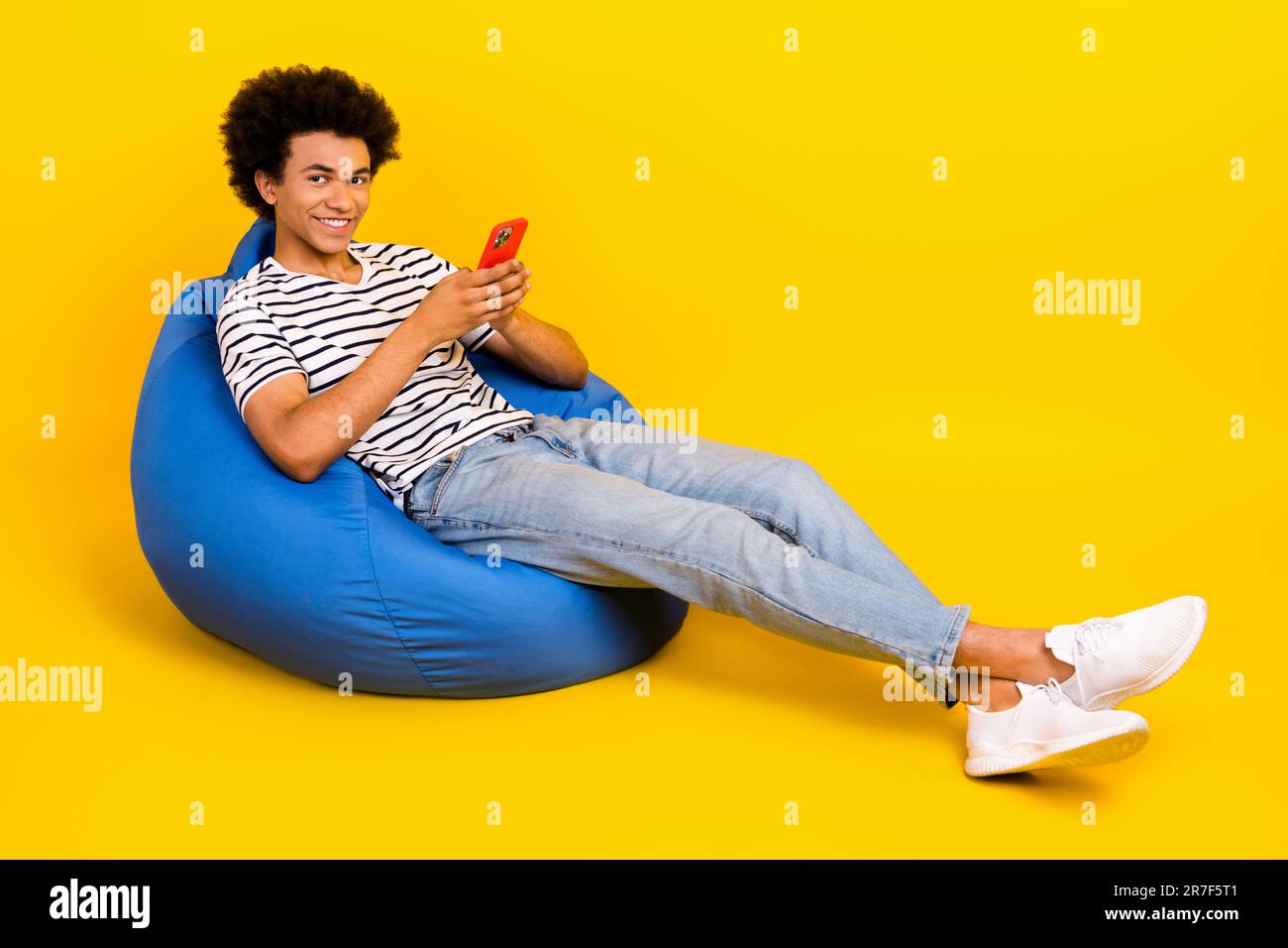 Full length photo of young relaxed man using his smartphone lie rest ...