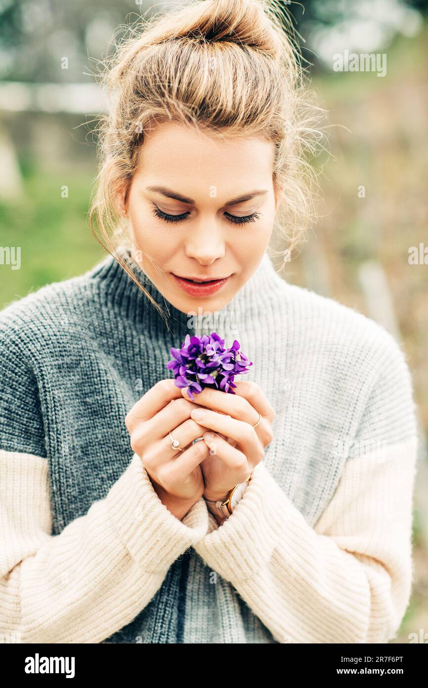 Spring portrait of pretty young woman wearing warm grey pullover ...