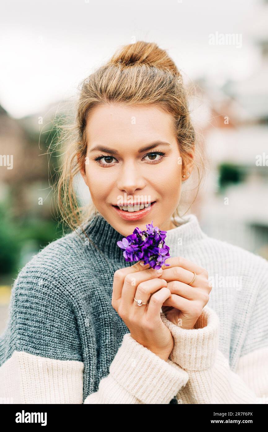 Spring portrait of pretty young woman wearing warm grey pullover ...