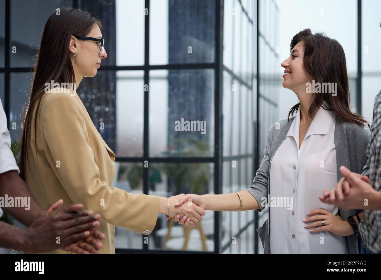 Two professional business people shaking hands in an office lobby Stock ...