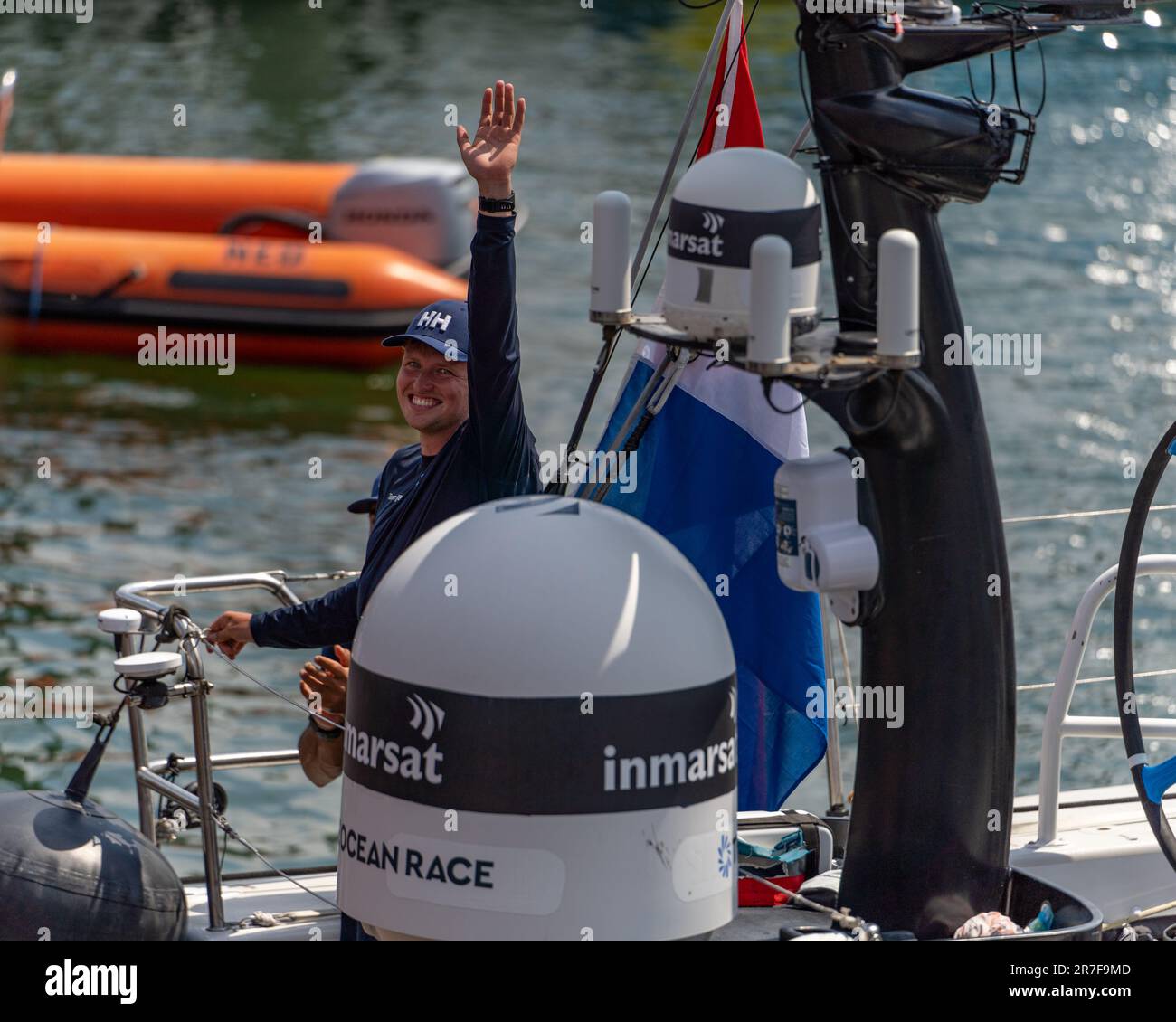 The Ocean Race sailor waving his hand while standing on the top of a ...