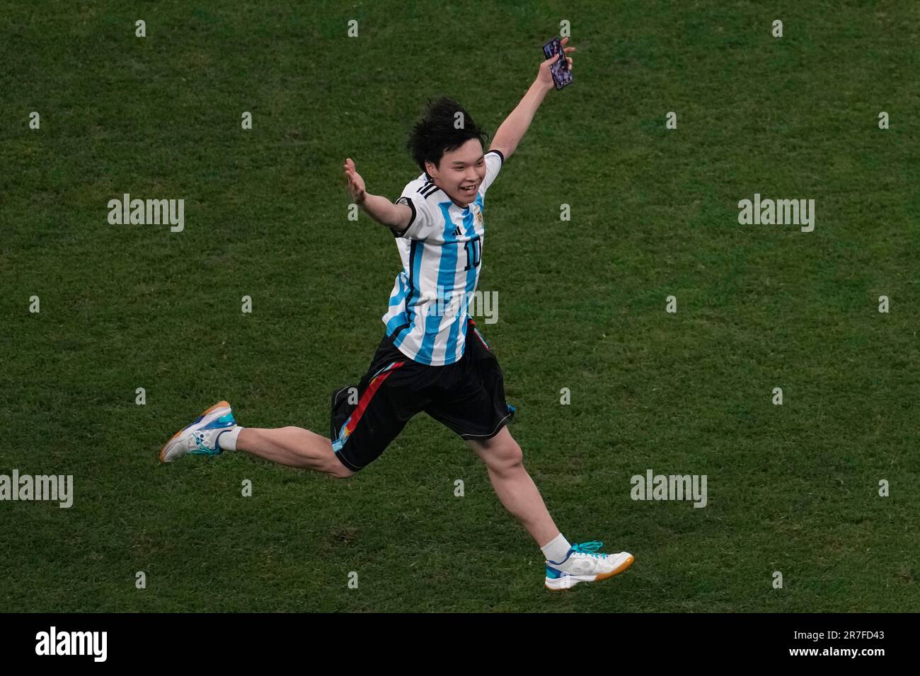 A Chinese fan of Argentina runs across the pitch after hugging Lionel ...