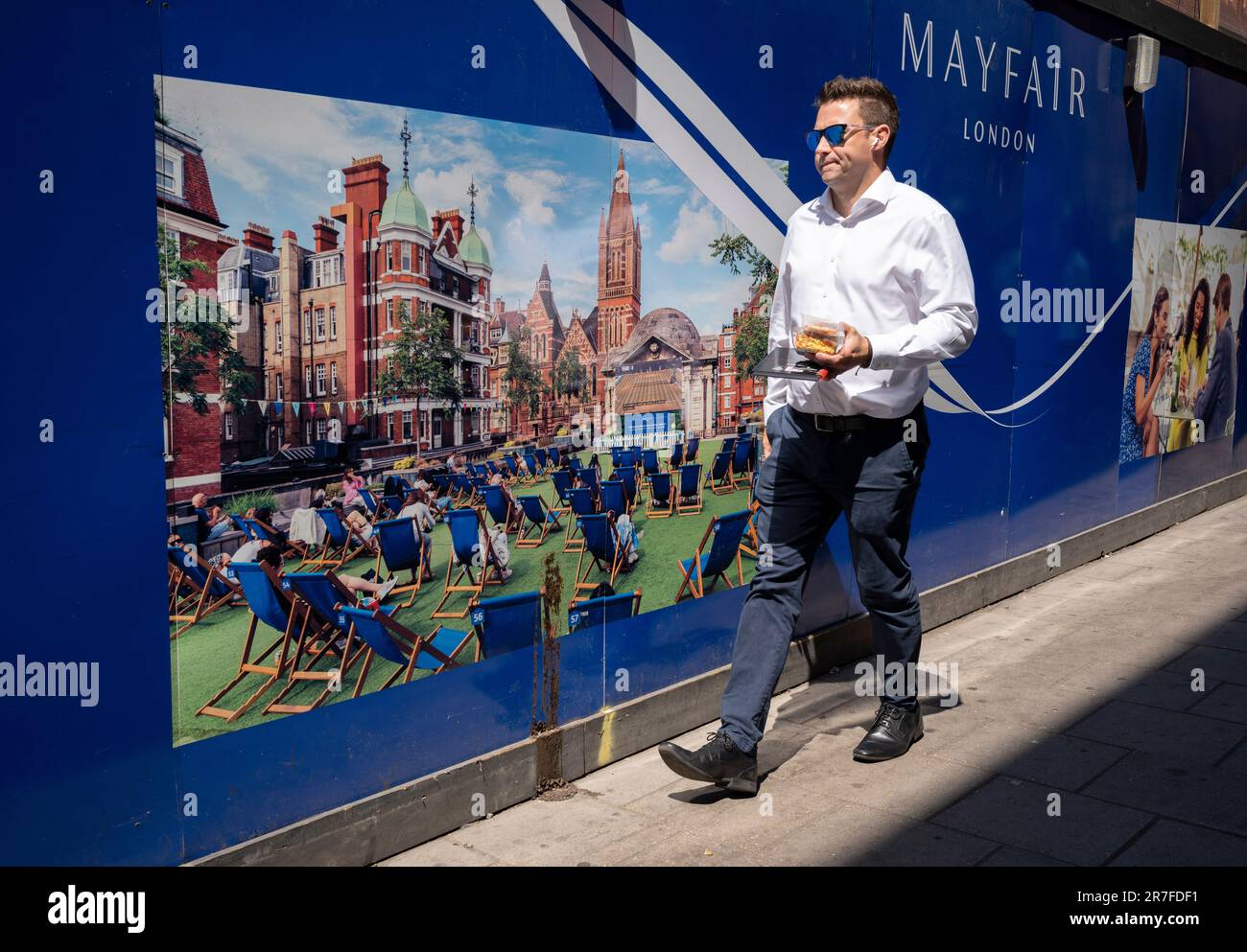 A man walks past a temporary construction hoarding in Mayfair, on 15th ...