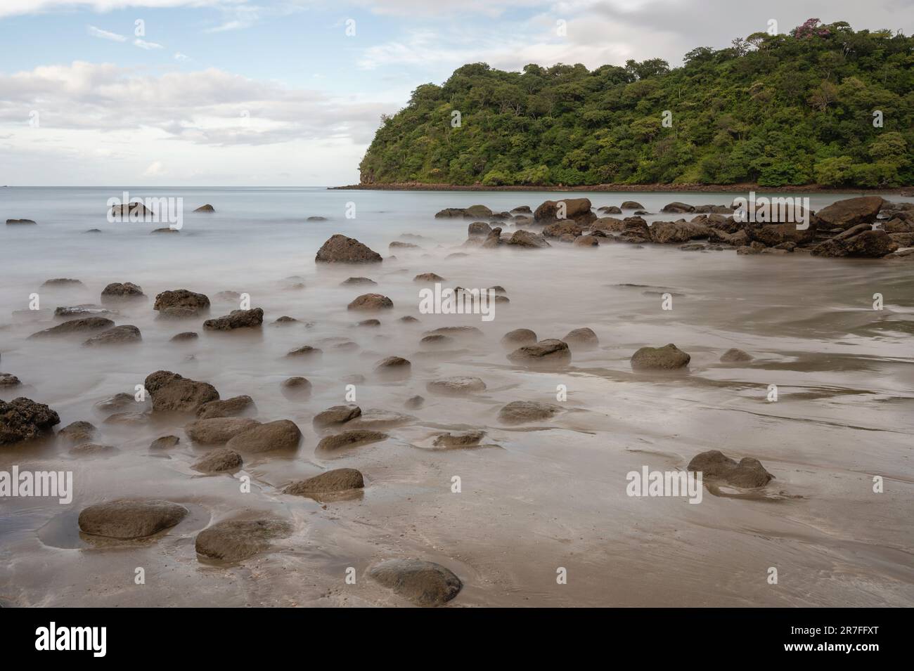 Rocks in silky sea water. Many brown stones on sea shore Stock Photo ...