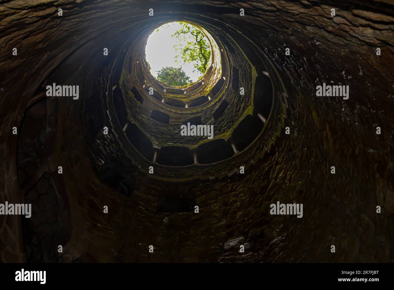 A surreal landscape featuring an open sewer with a bright light at the ...