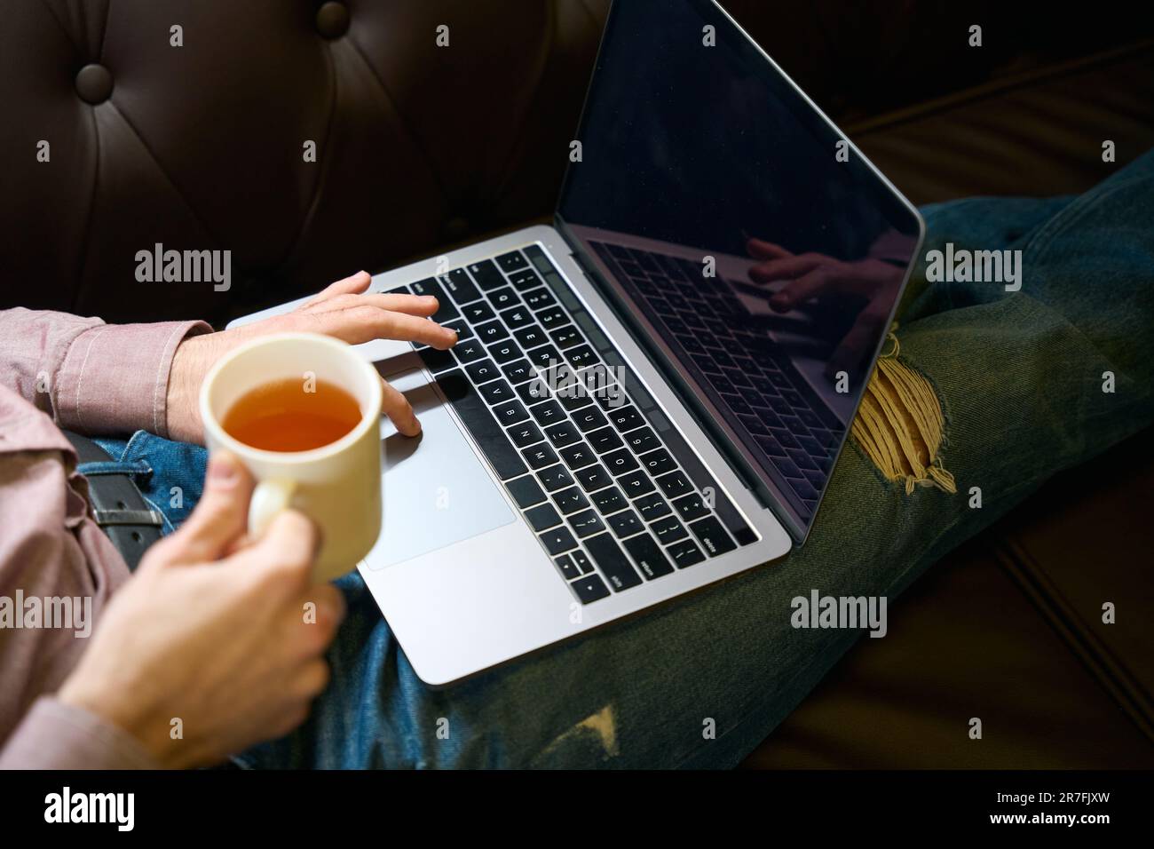 Male using portable computer during tea break Stock Photo - Alamy