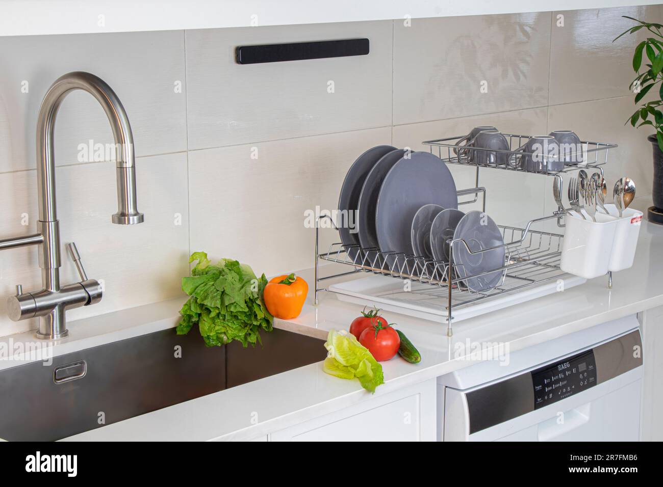 A modern kitchen with multiple dishes, fresh fruit, and vegetables near ...