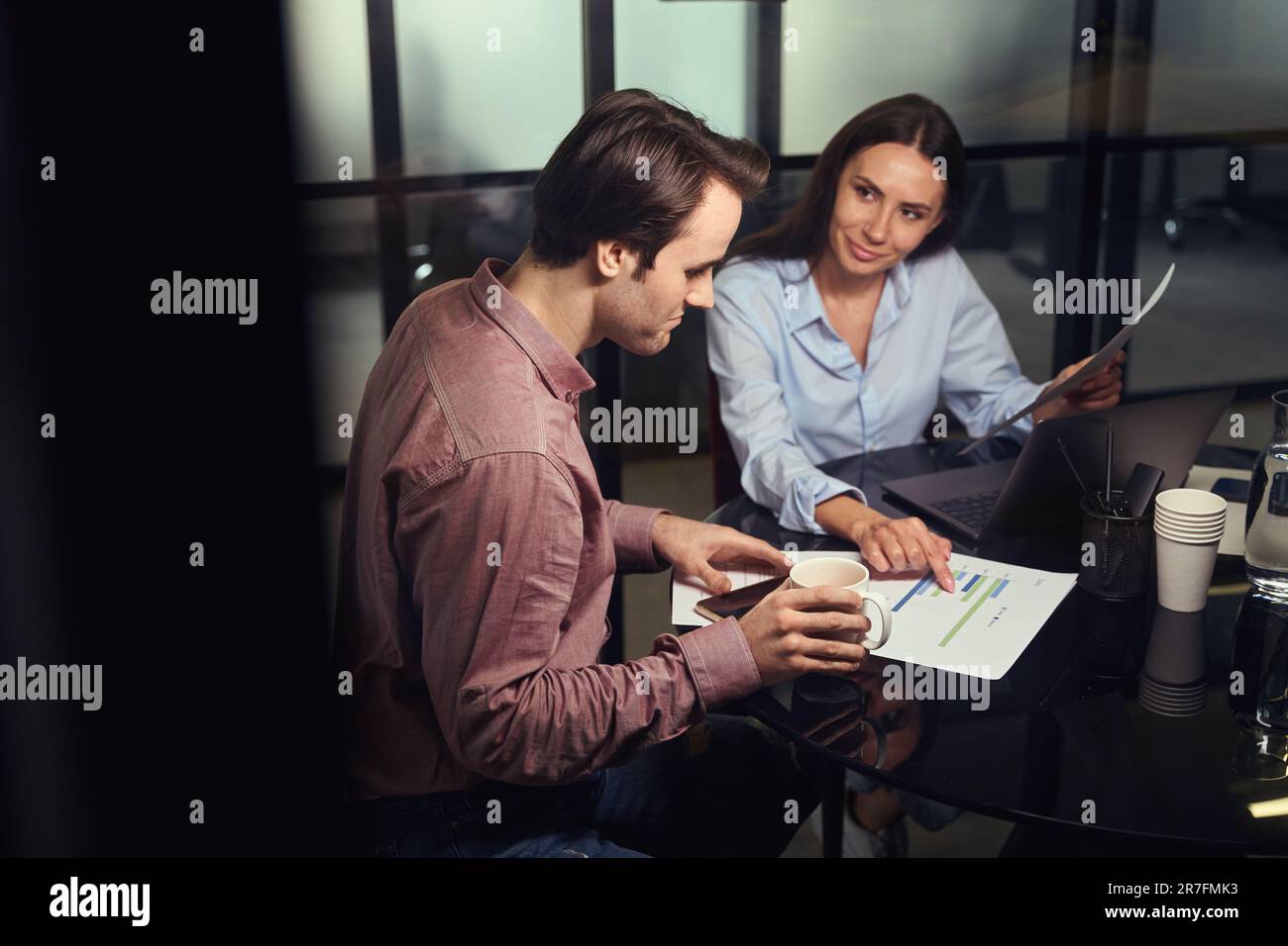 Two office workers dealing with documentation at business meeting Stock ...