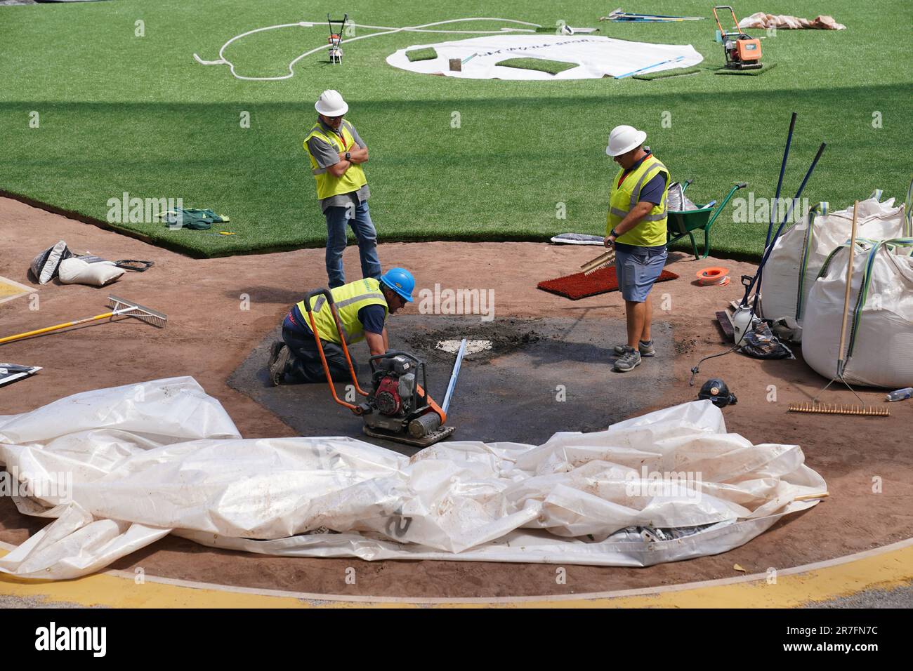 Workers transform the pitch into a baseball field at the London Stadium ...