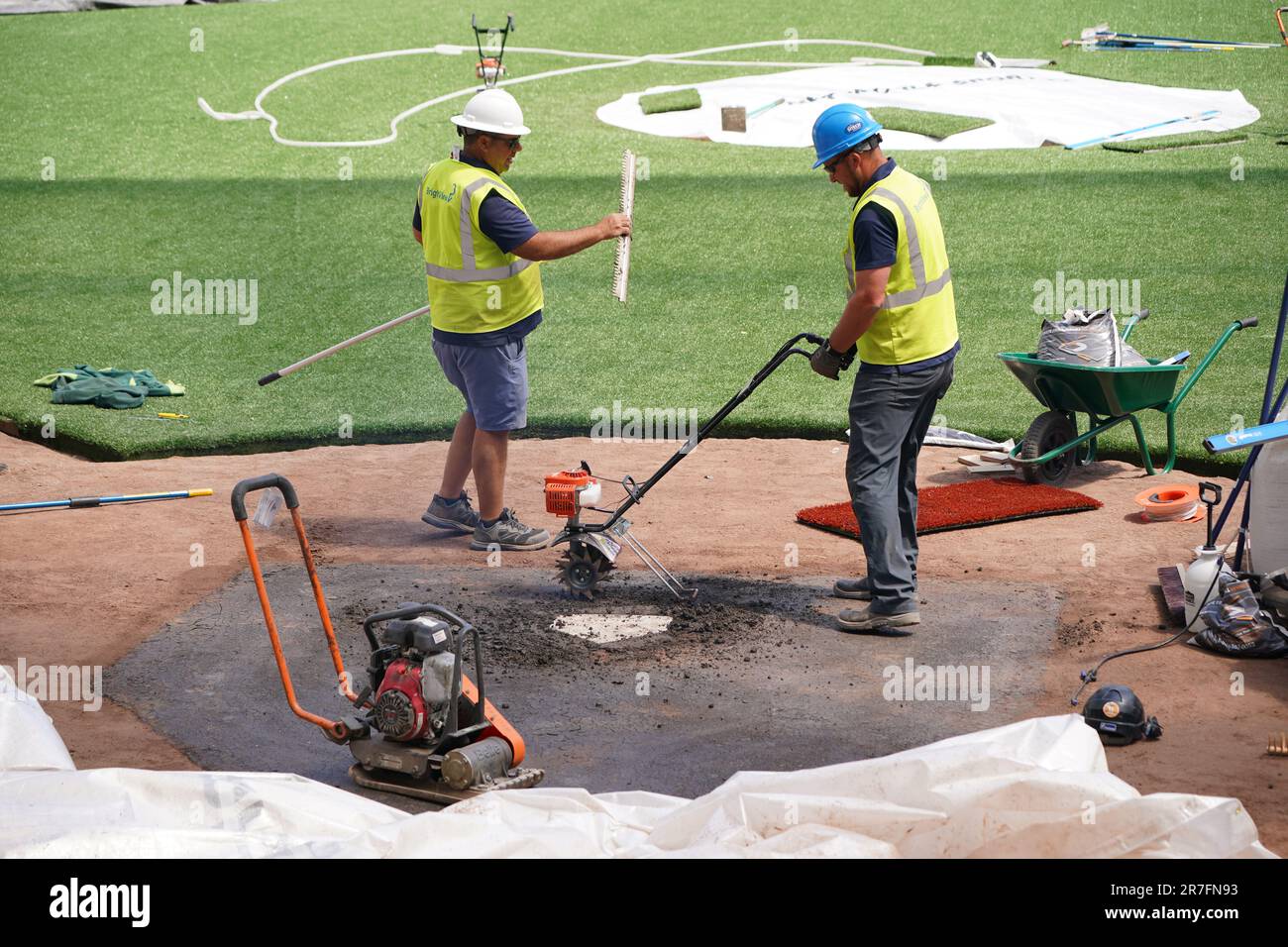 Workers transform the pitch into a baseball field at the London Stadium ...