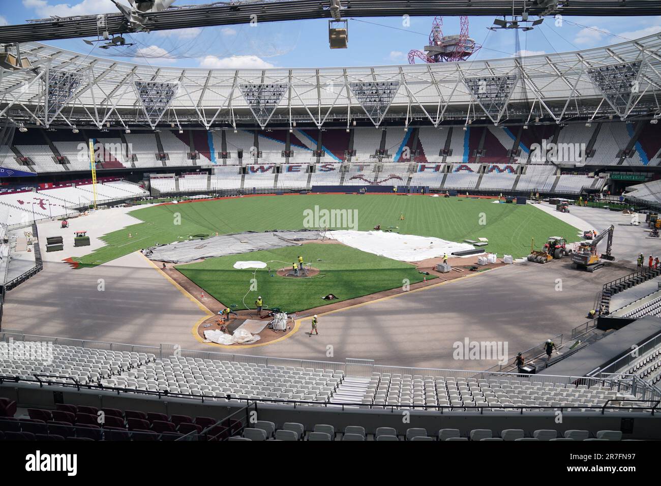 Workers transform the pitch into a baseball field at the London Stadium ...