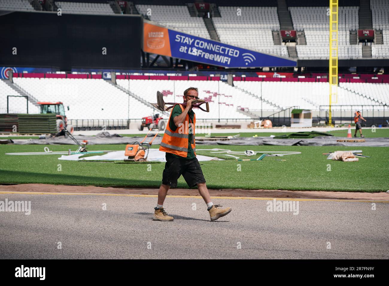 Workers transform the pitch into a baseball field at the London Stadium ...