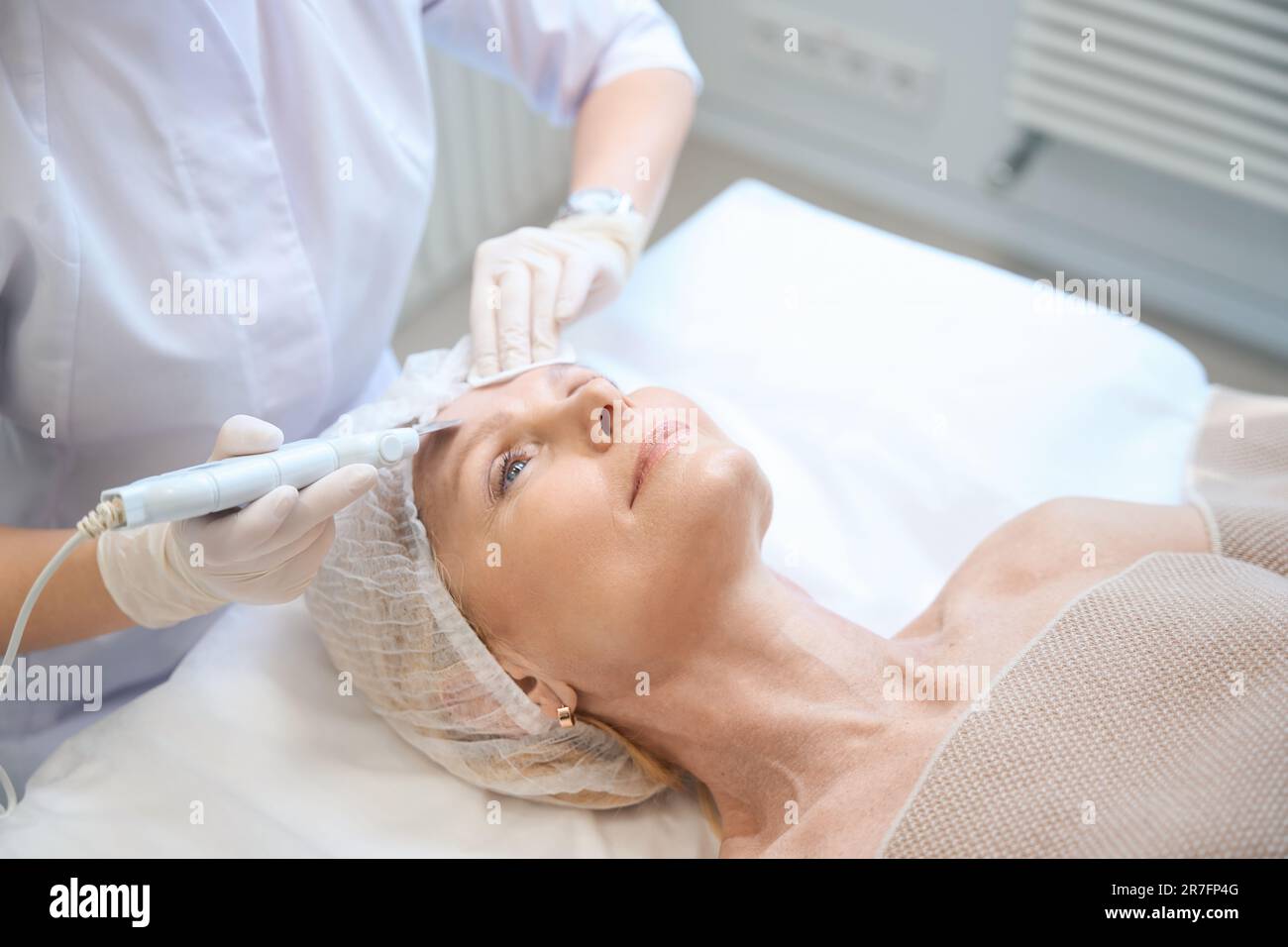 Smiling adult woman getting microcurrent therapy in beauty salon Stock Photo - Alamy