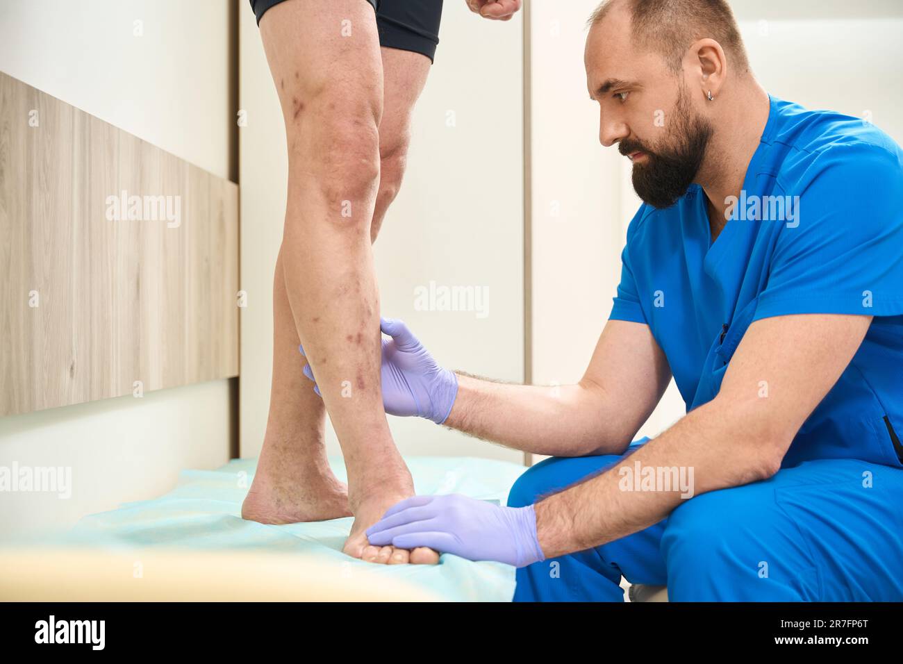 Surgeon cardiologist carefully examining veins on patient legs Stock ...