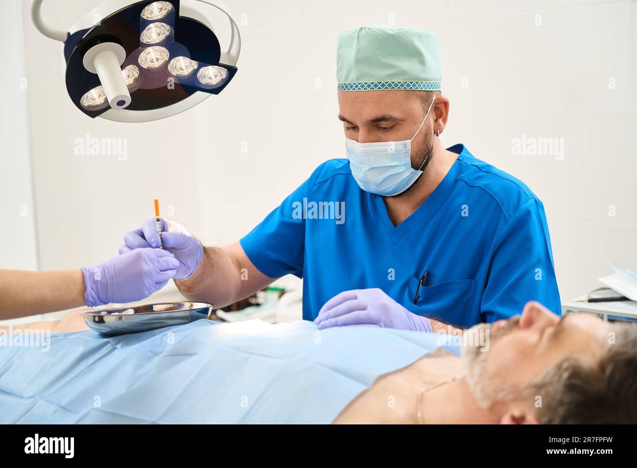 Male surgeon takes syringe for injection from hands of assistant Stock ...