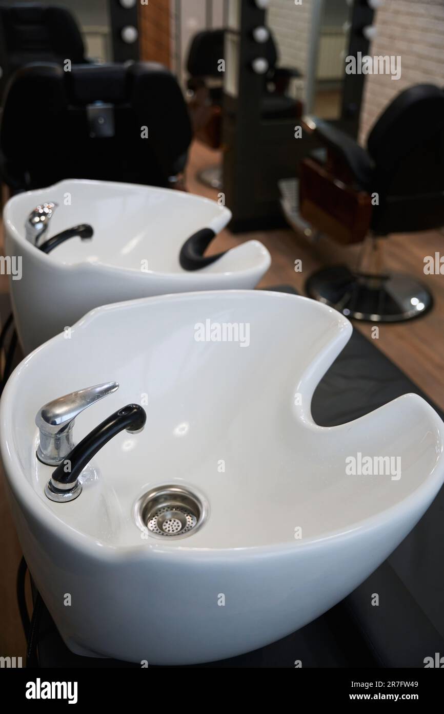 Sinks for washing hair in a barbershop with minimalist interior Stock ...