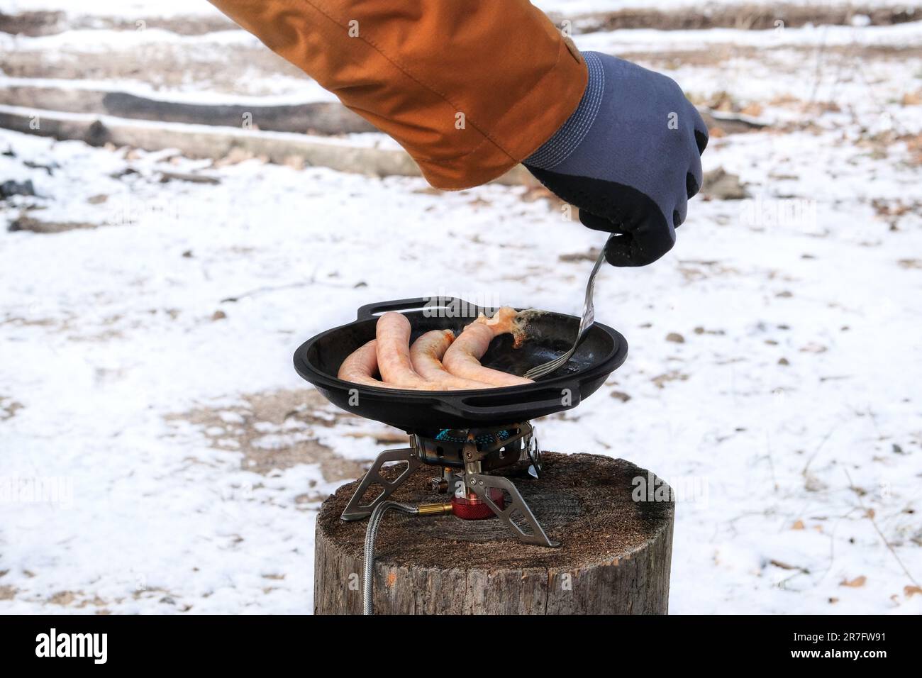Sausages in bowler in the forest in winter. Camping food making ...