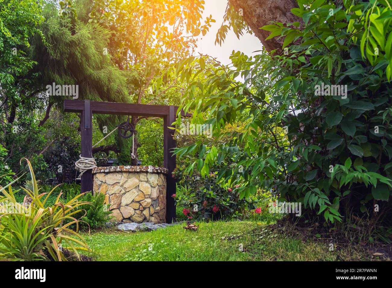 Beautiful artesian well made by stones and wheel pulley with metal ...