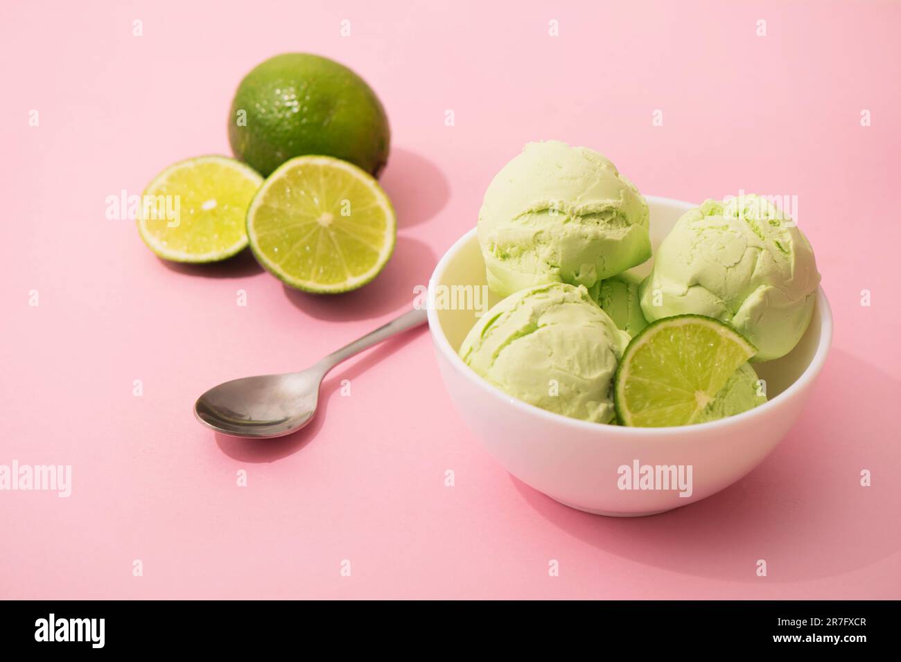Ice cream with lime flavor and slices of fresh lime in a white bowl ...