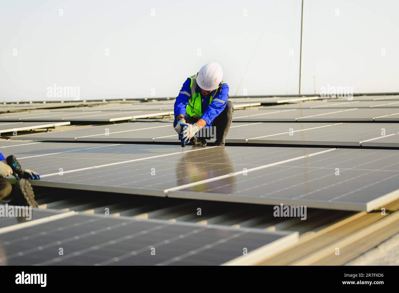 Maintenance technicians installing solar panels at solar cell farm ...