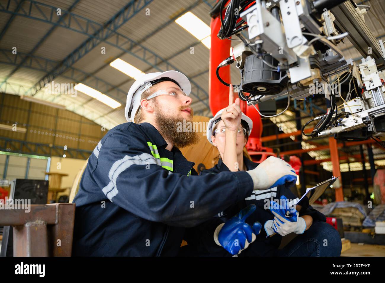 Mechanical engineers repairing engine machine at factory Stock Photo ...