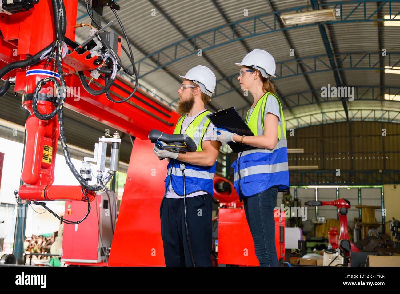 Mechanical engineers repairing engine machine at factory Stock Photo ...