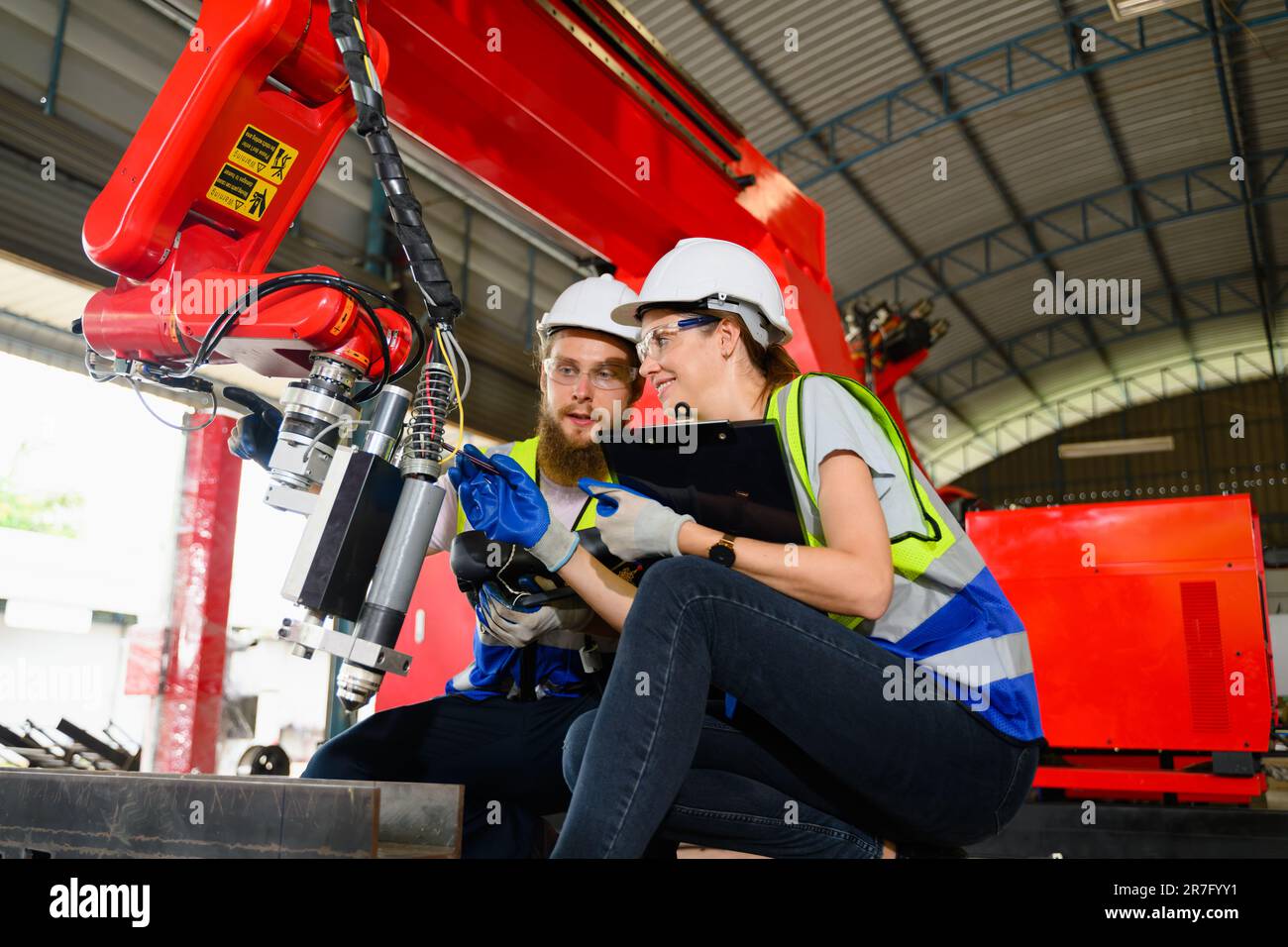 Mechanical engineers repairing engine machine at factory Stock Photo ...