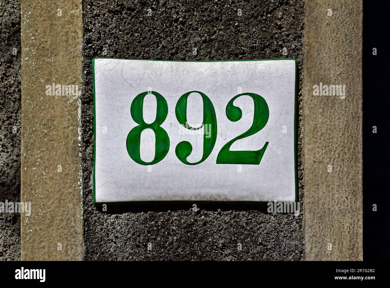 Street sign number 892 on a gray and yellow wall Stock Photo - Alamy
