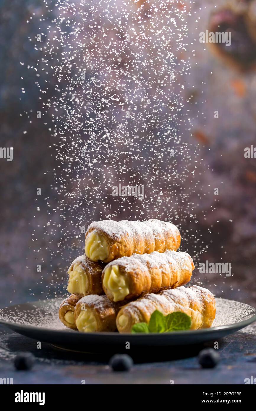Delicious puff pastry tubes filled with custard. Powdered Sugar Stock ...