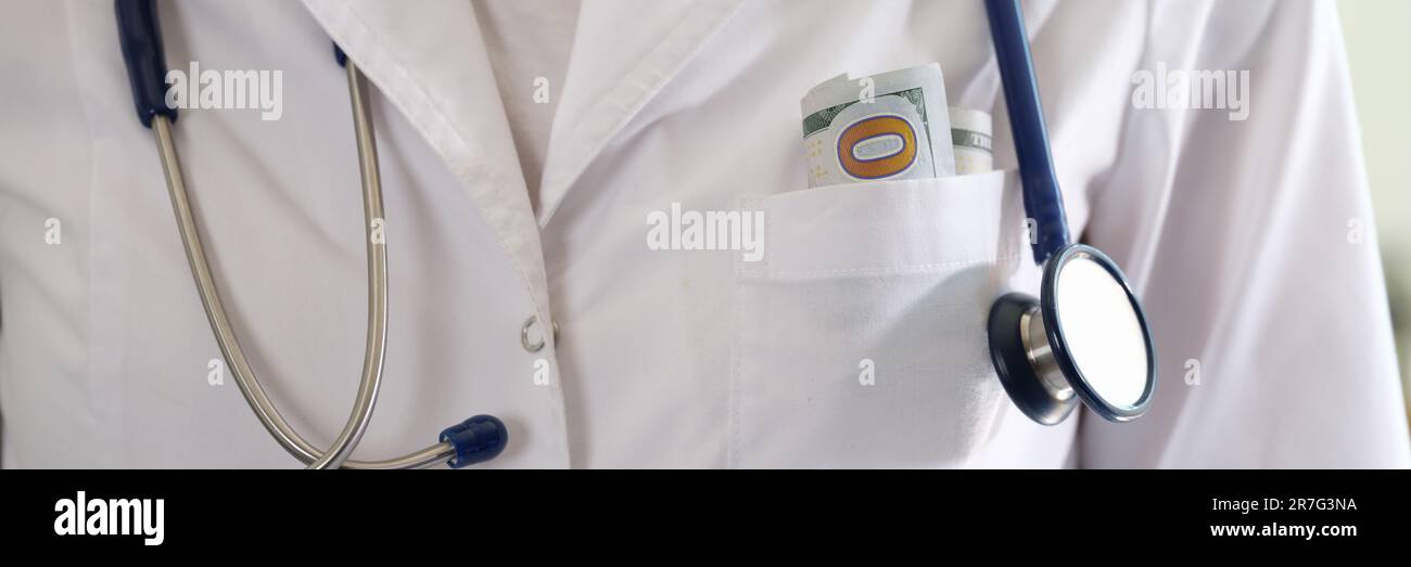 Money dollars in doctor pocket in clinic Stock Photo - Alamy