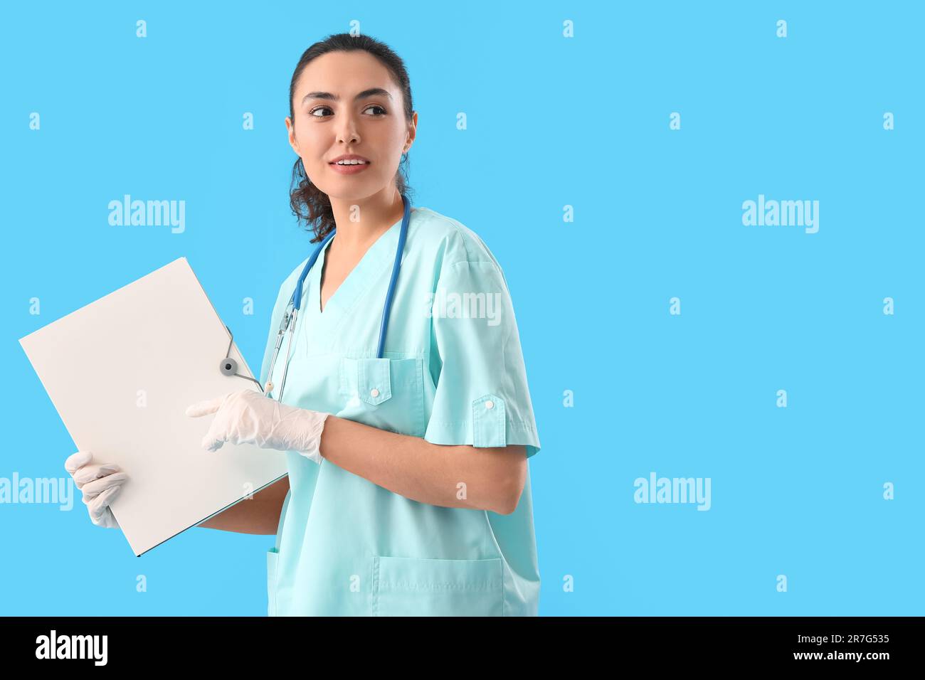 Female medical assistant with folder on light blue background Stock ...