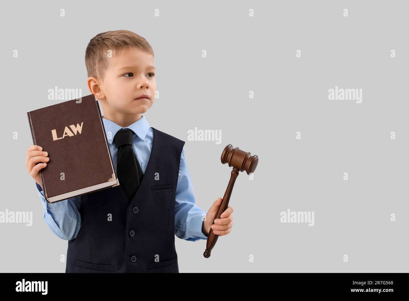 Cute little judge with law book and gavel on grey background Stock ...