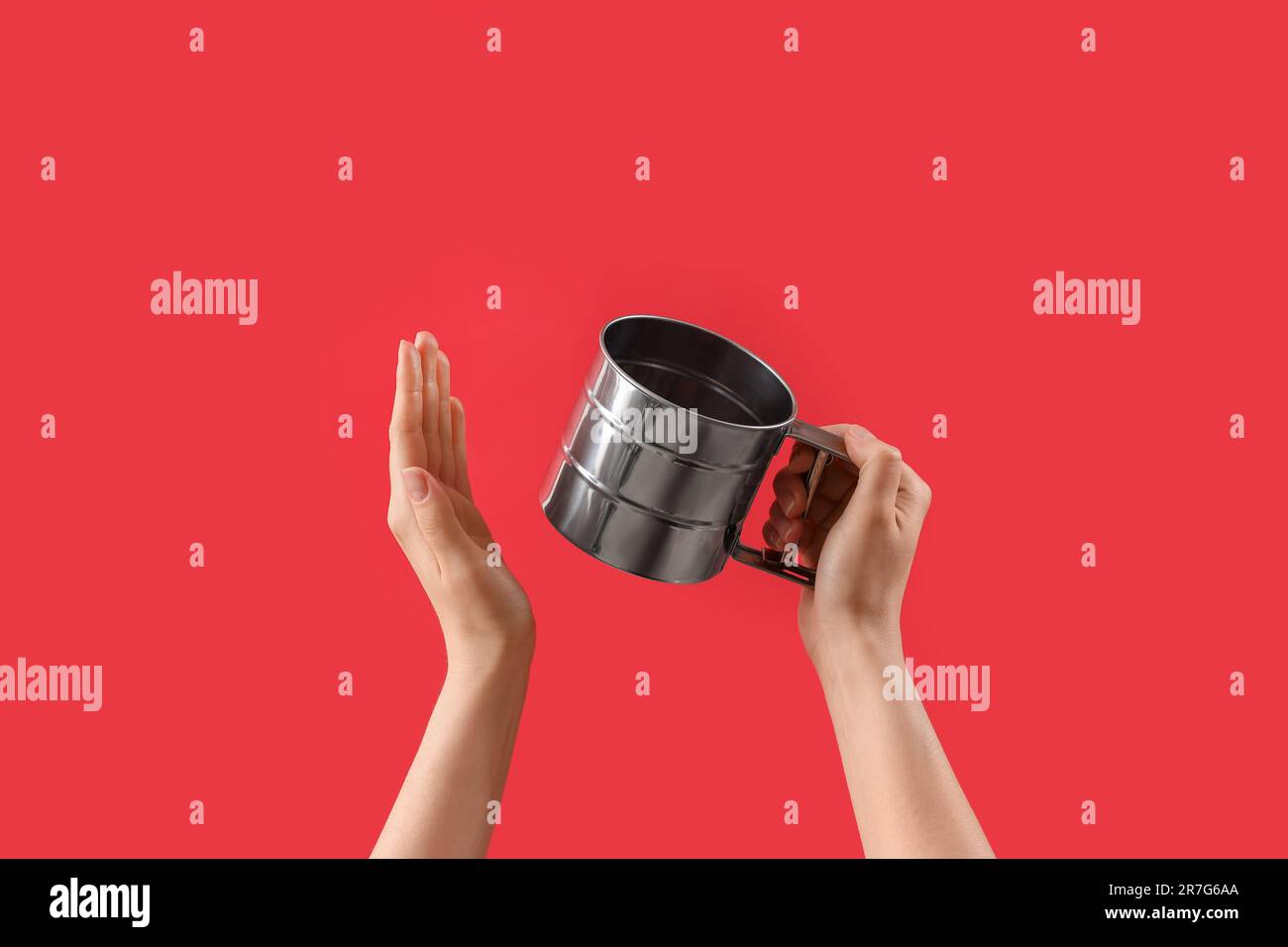Female hands holding measuring cup on red background Stock Photo - Alamy