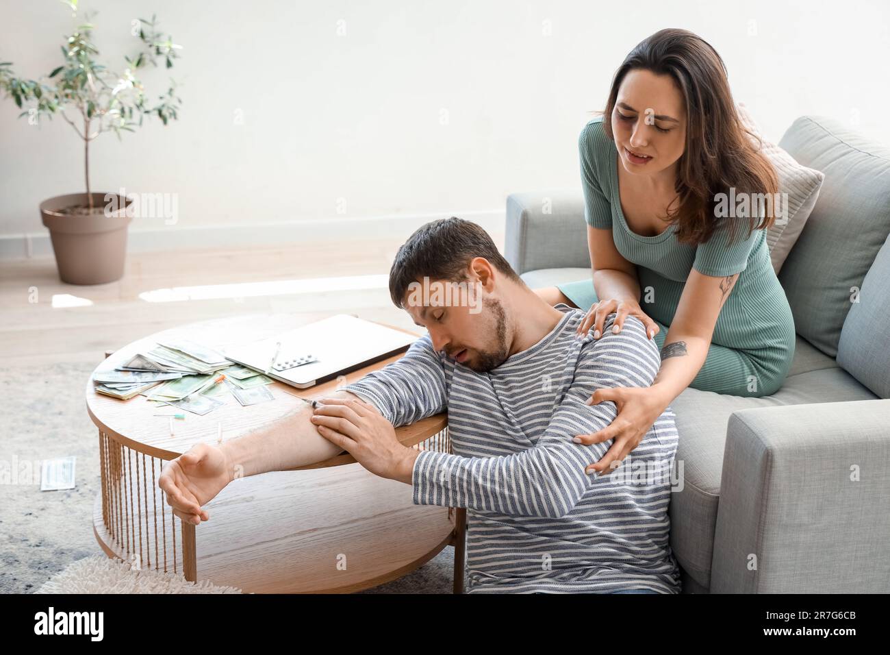Young pregnant woman with her addict husband at home. Domestic violence ...