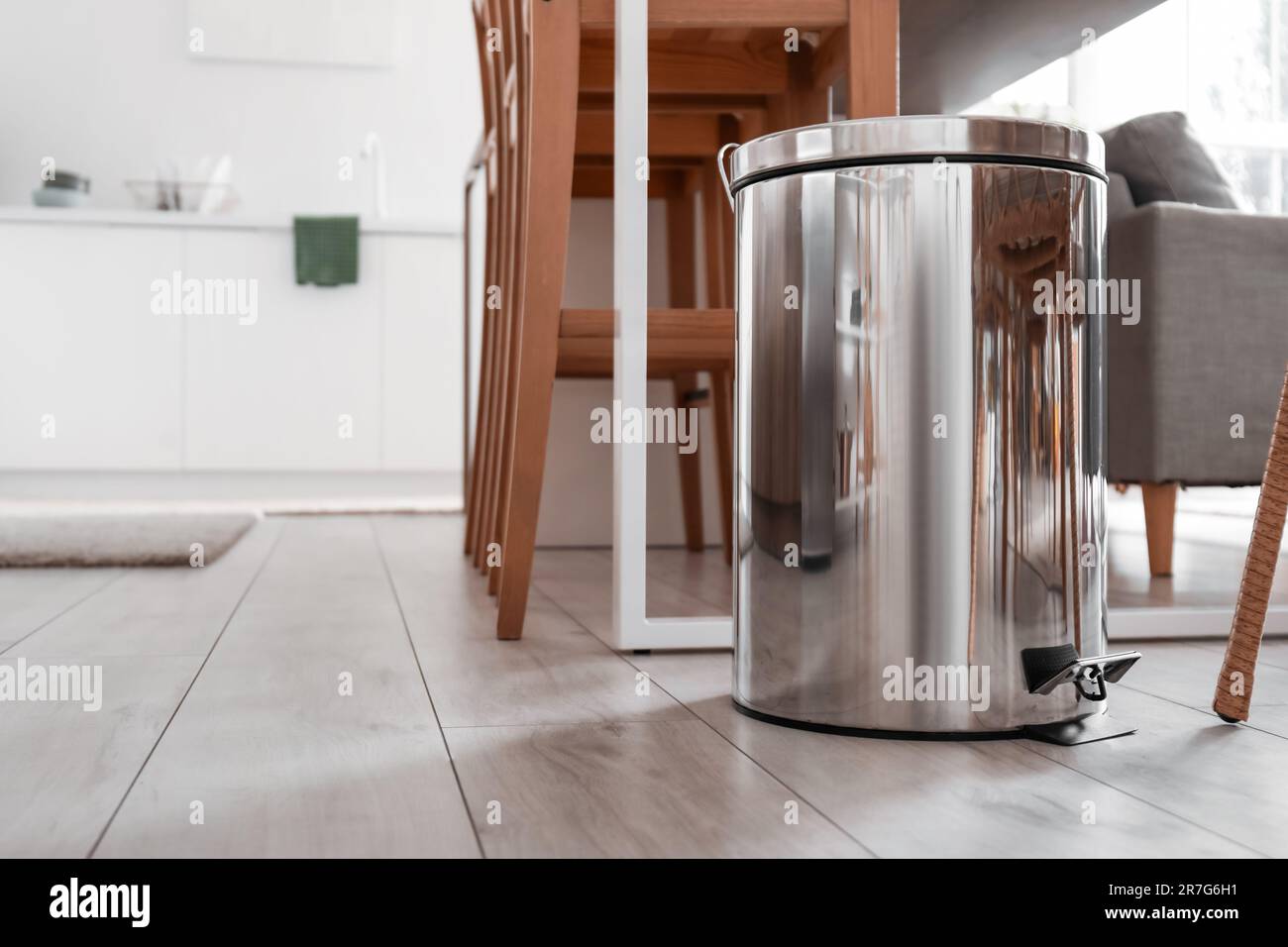 Metallic trash bin near table in interior of modern kitchen Stock Photo ...