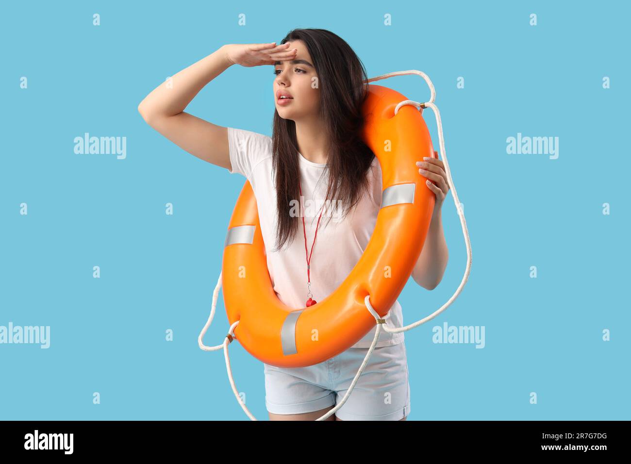 Female lifeguard with ring buoy on blue background Stock Photo - Alamy