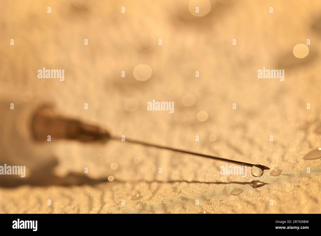 Abstract medical background. Blurred syringe with a drop. Drop of ...