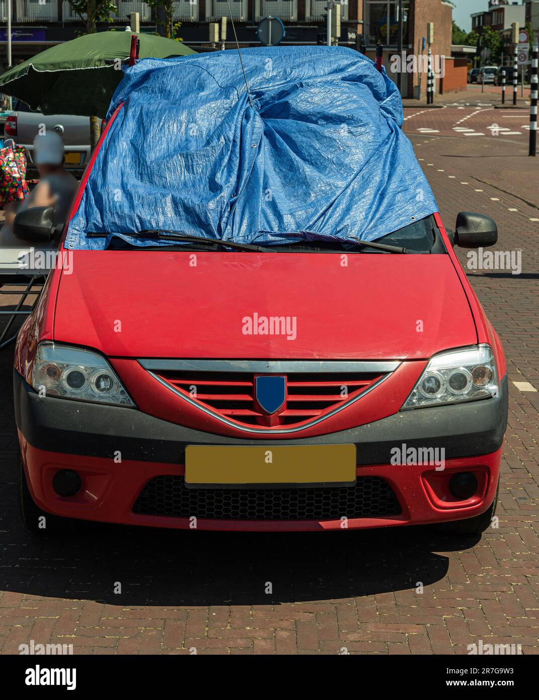 red car whose windshield is covered with a blue plastic sheet Stock ...
