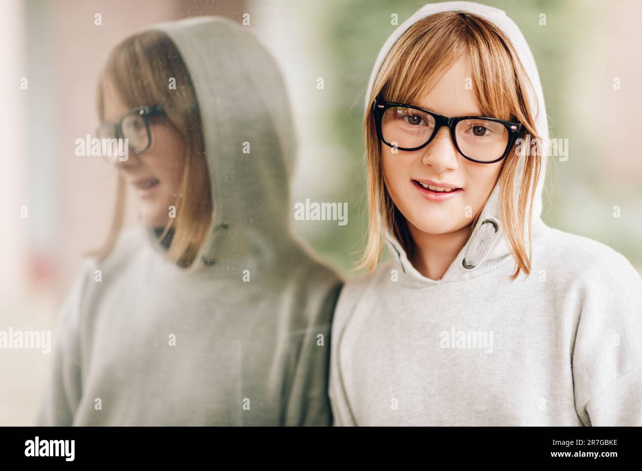 Outdoor portrait of a cute little 10 year old girl wearing eyeglasses ...