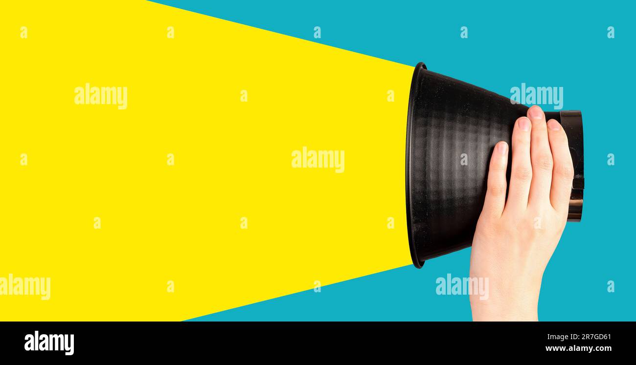 Hand holding bullhorn, loudspeaker with beam from it, banner background ...