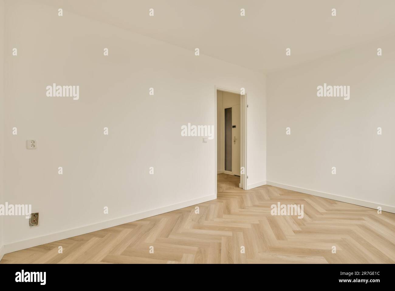 an empty room with white walls and parqueted wood floor in the middle ...