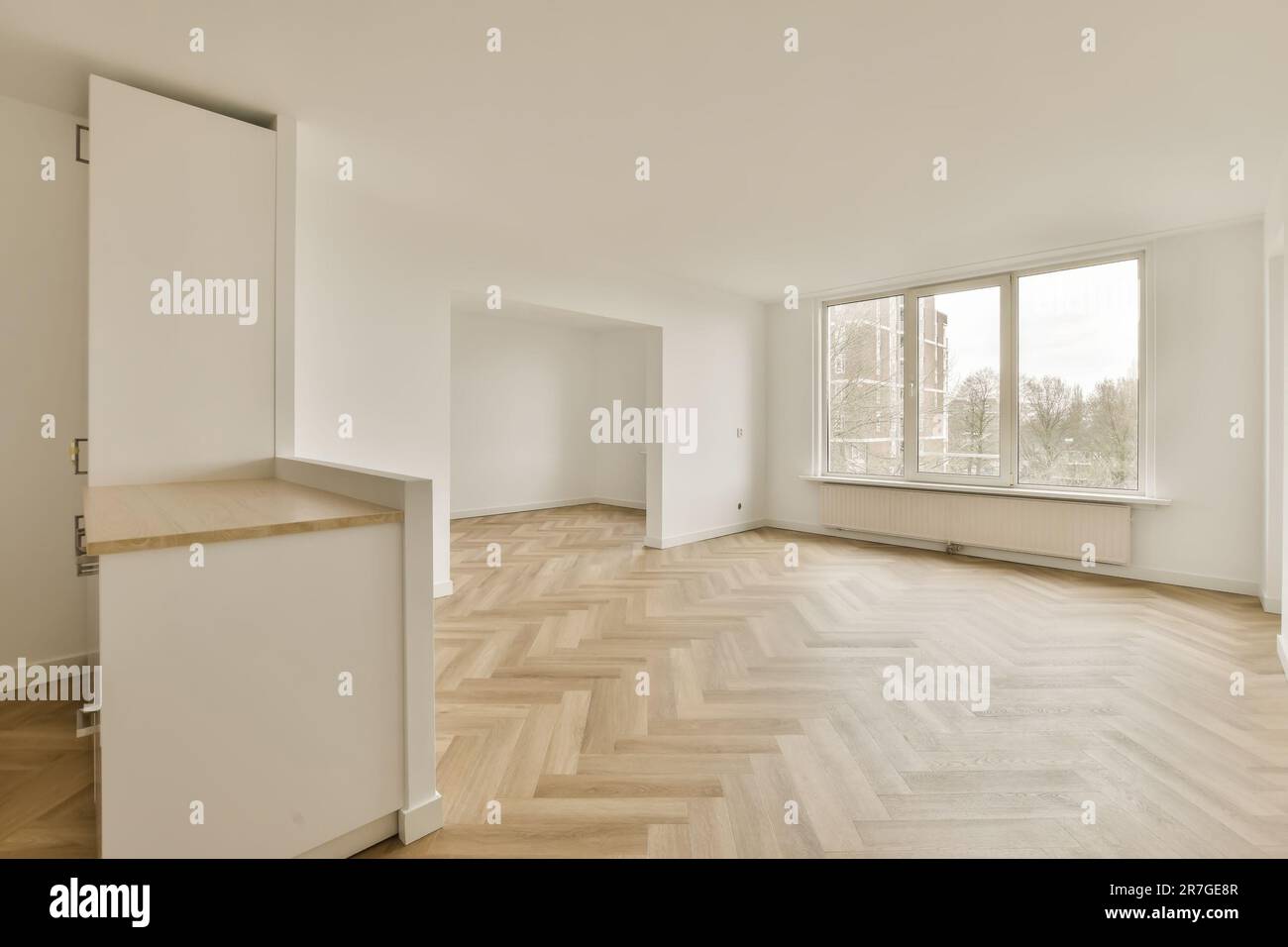 an empty living room with wood flooring and large windows in the room ...