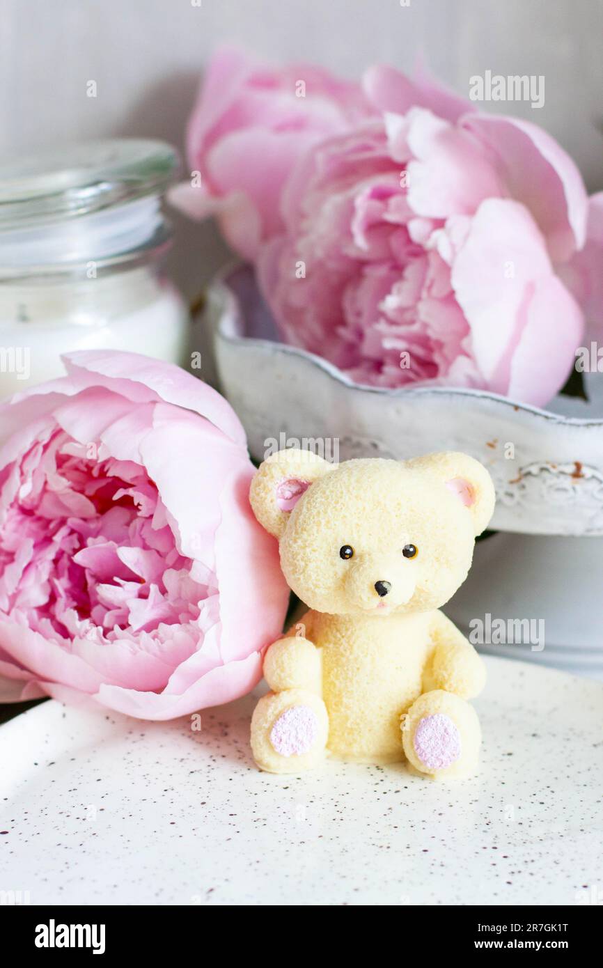 Cute edible teddy bear toy made of white chocolate with fresh peonies ...