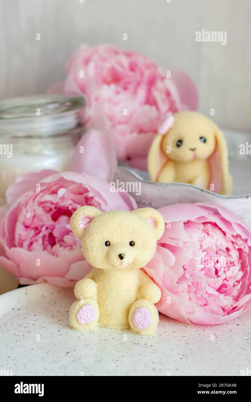 Cute edible teddy bear toy made of white chocolate with fresh peonies ...