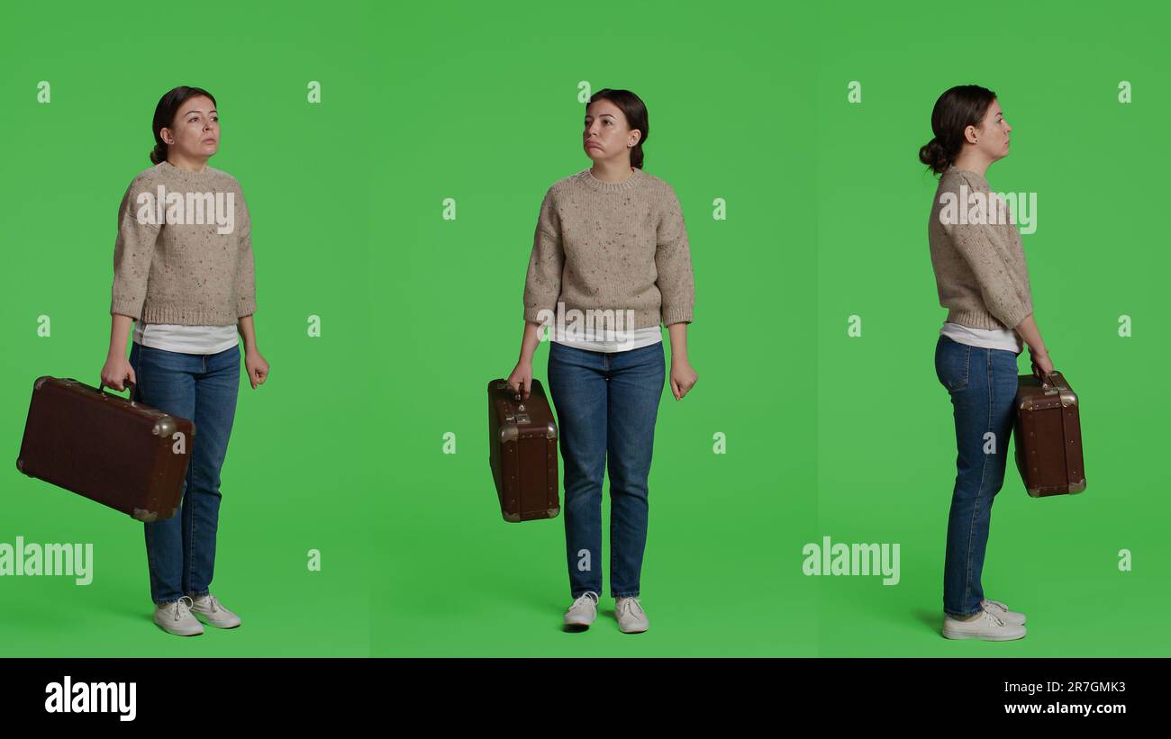 Casual person carrying vintage suitcase in studio, posing with ...