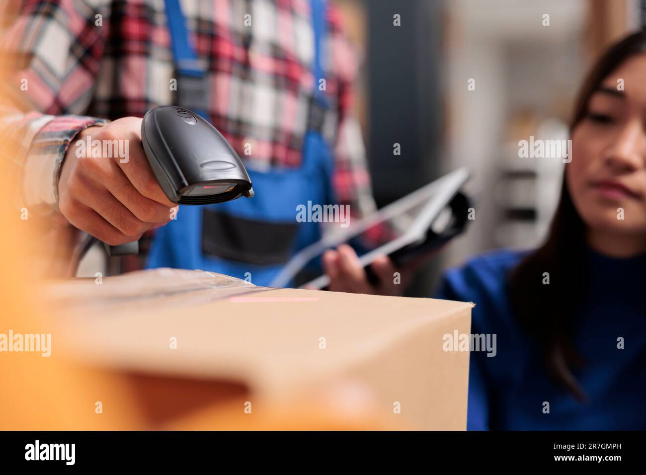 Freight distribution center employee using barcode scanner in warehouse ...