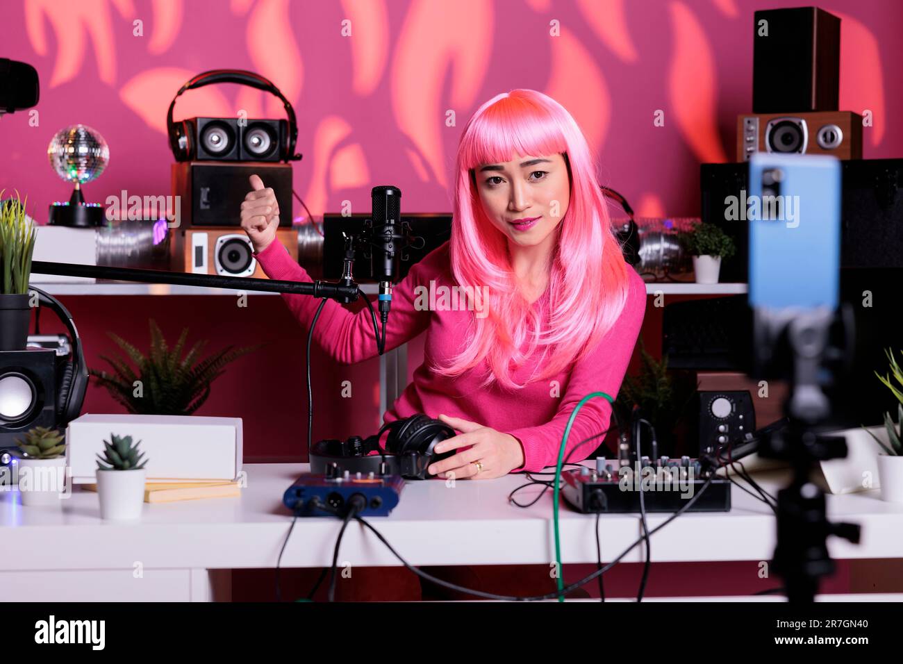 Asian influencer sitting at desk table in vlogging studio recording ...