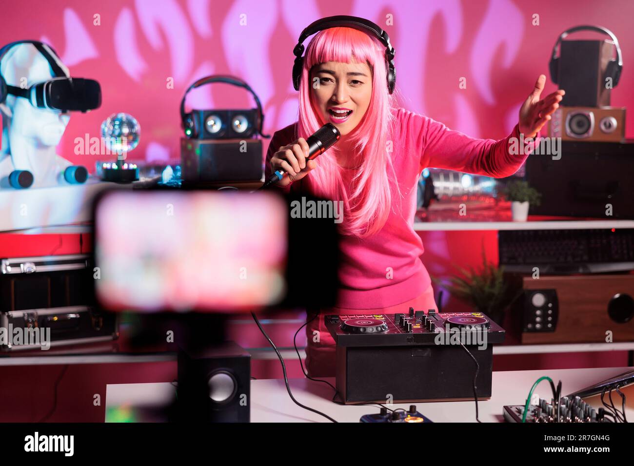 Smiling woman standing at dj table playing techno music at mixer ...
