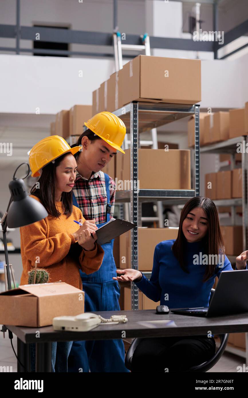 Storehouse employees getting inventory instruction from operator and ...